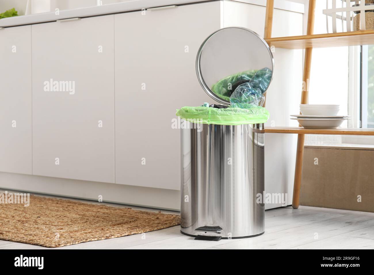 Opened trash bin with garbage in interior of light kitchen Stock Photo ...