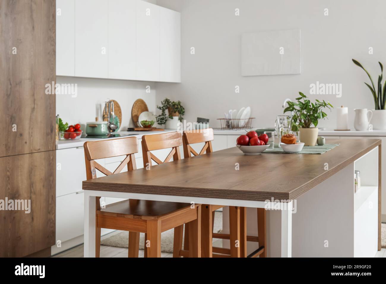Wooden island table in interior of modern kitchen Stock Photo - Alamy