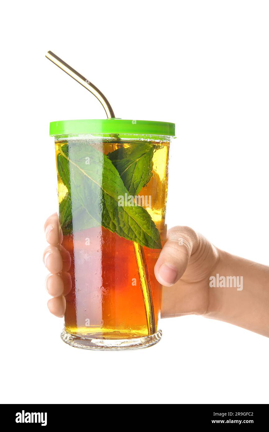 Female hand holding glass of ice tea with mint on white background ...