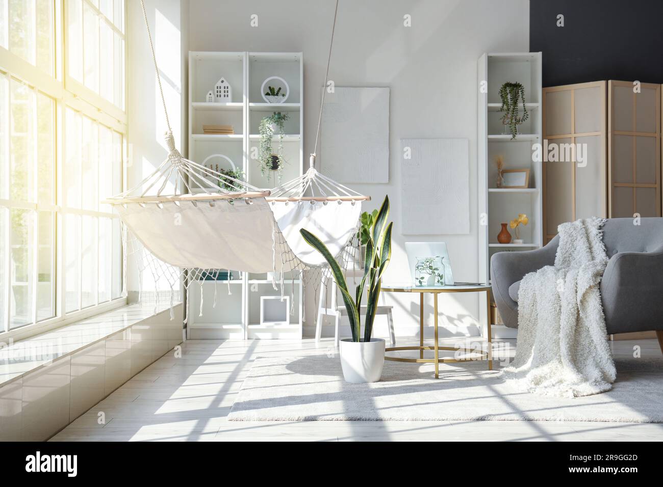 Interior of light living room with hammock, table and armchair Stock ...