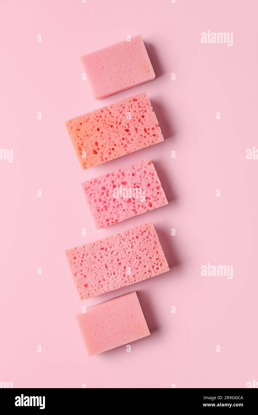 Row of different sponges on pink background Stock Photo - Alamy