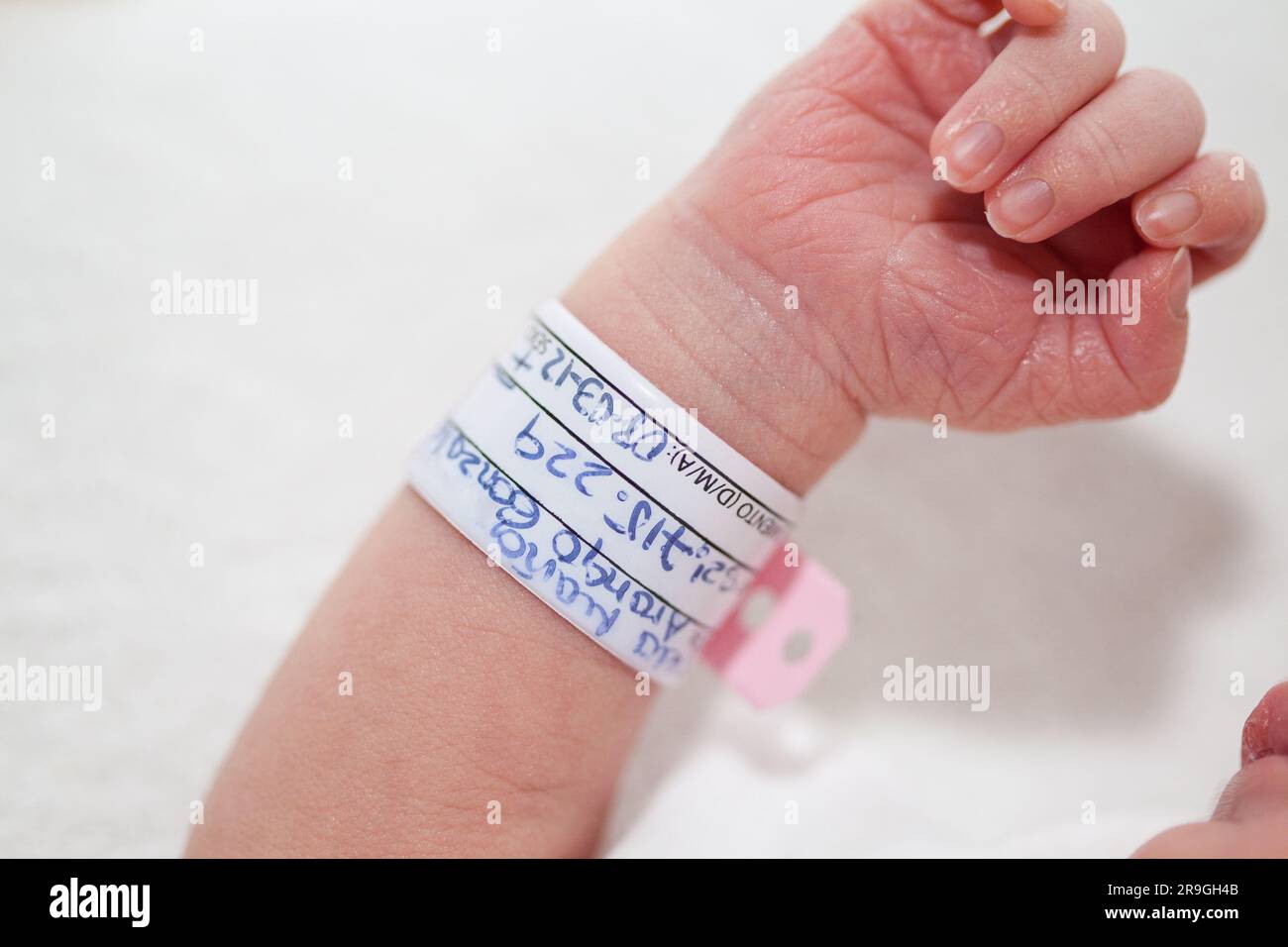 Closeup of a newborn arm and bracelet at hospital on the day of her ...