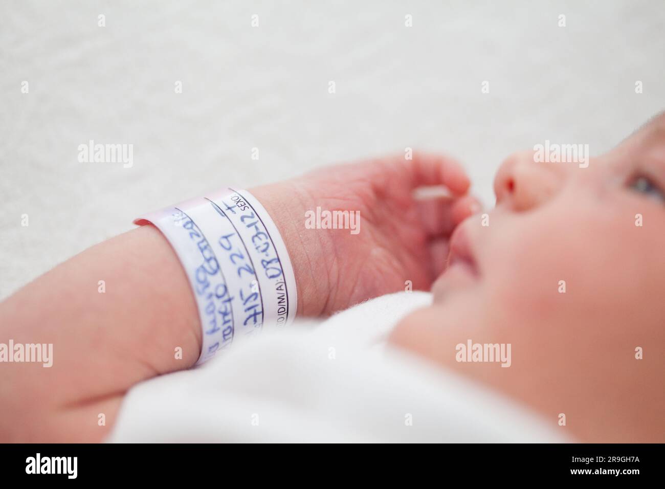 Closeup of a newborn arm and bracelet at hospital on the day of her ...