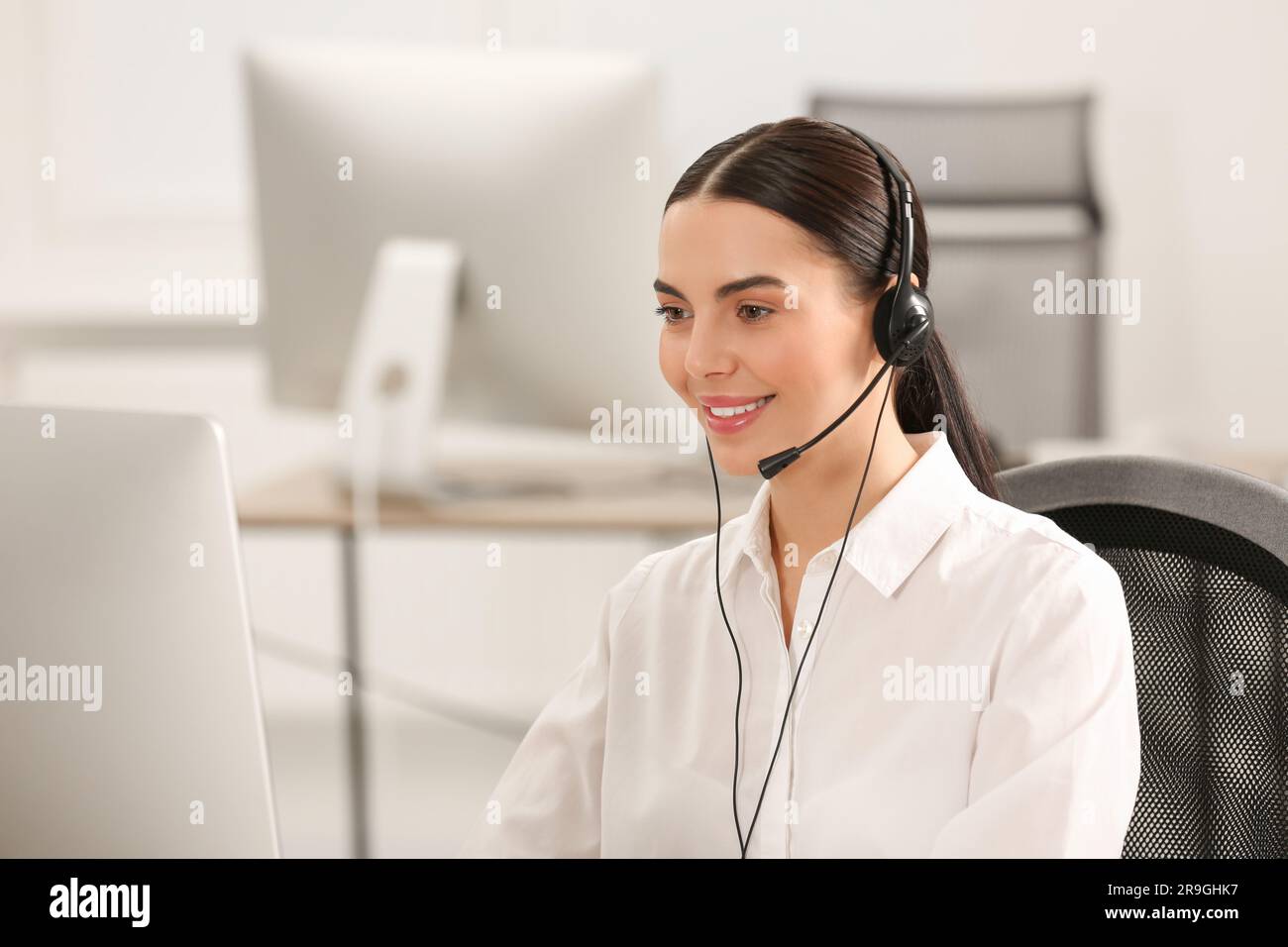 Hotline operator with headset working on computer in office Stock Photo ...