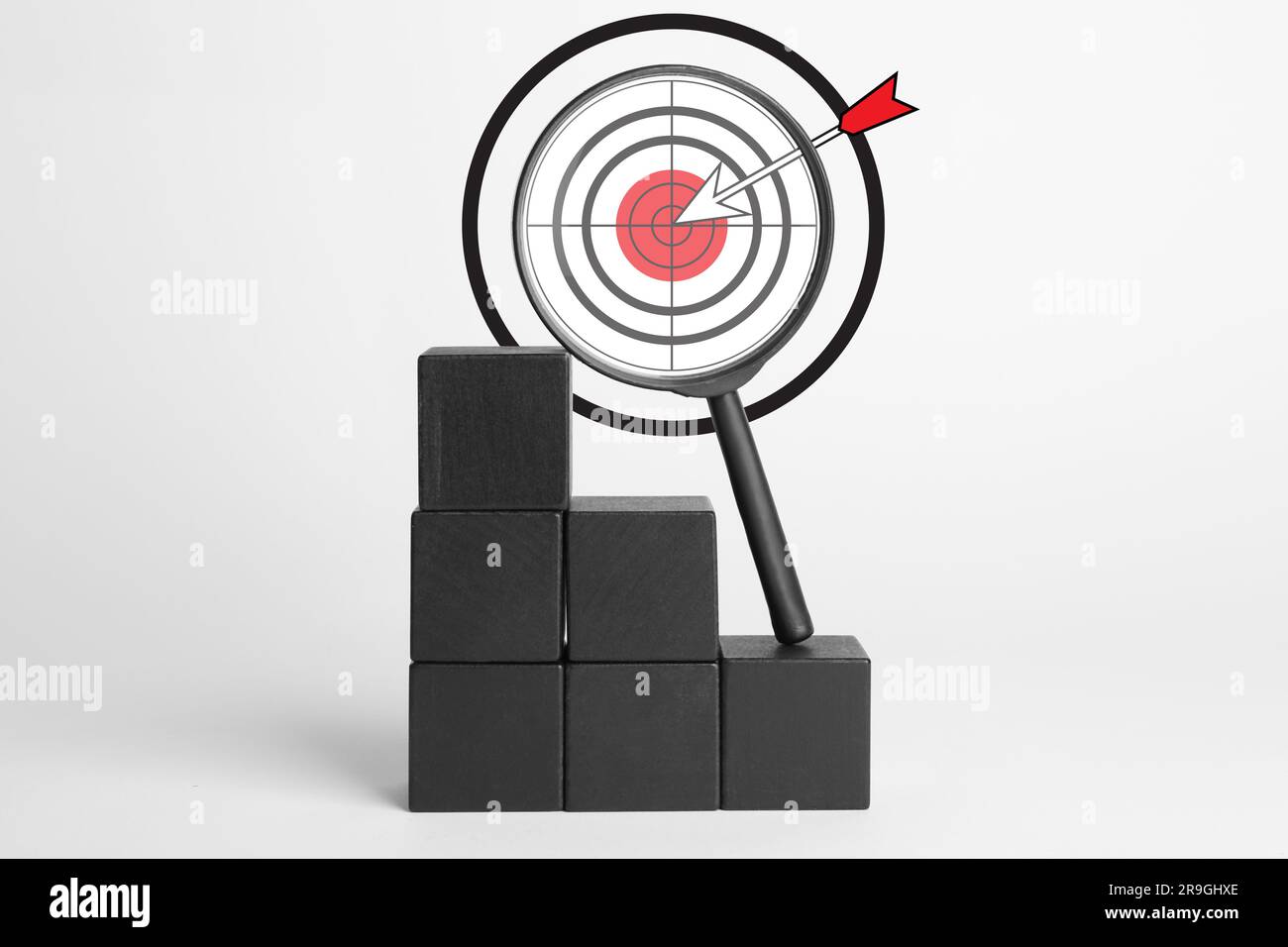 Magnifying glass with illustration of target and arrow on black cubes ...