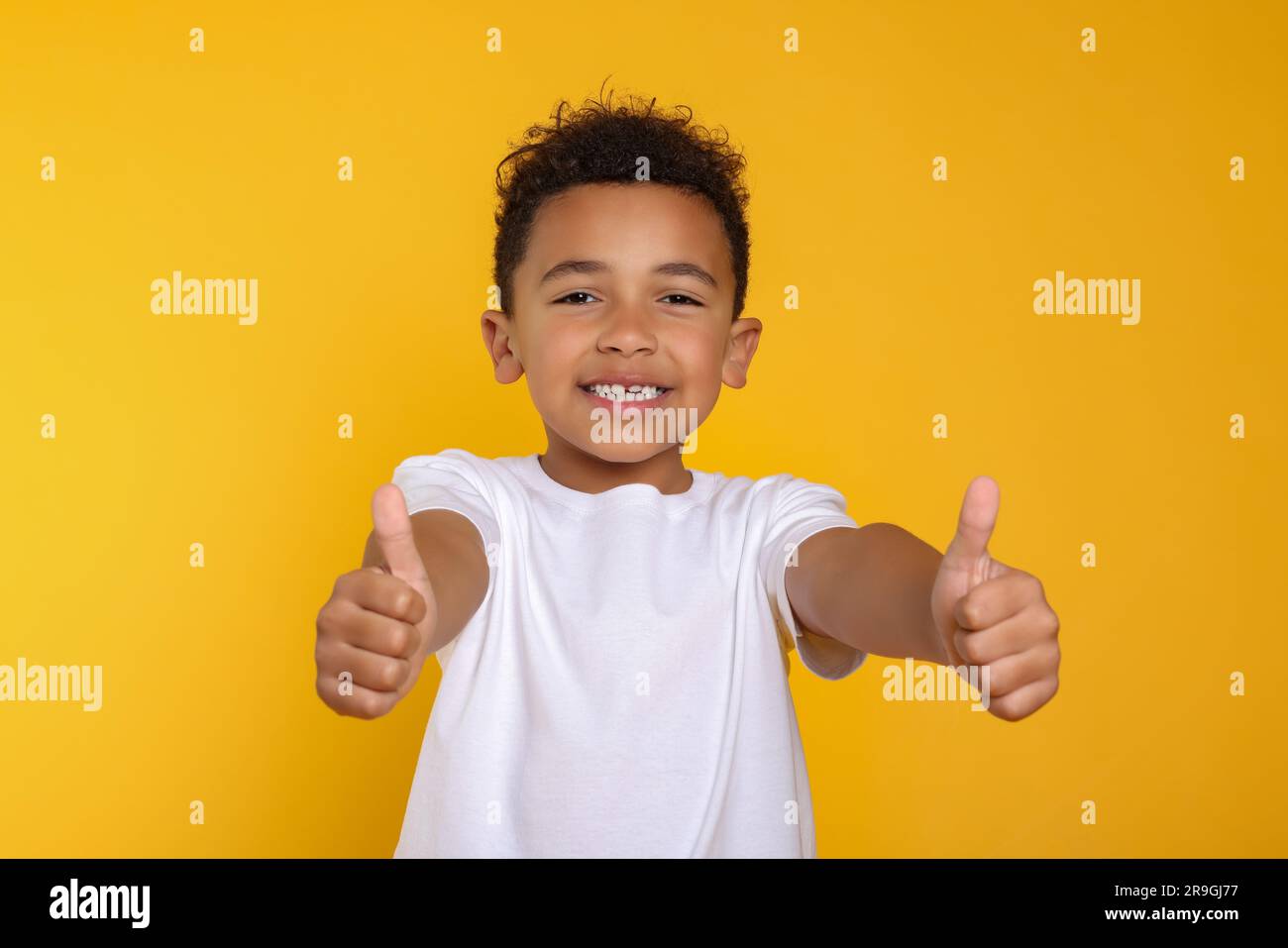 African-American boy showing thumbs up on yellow background Stock Photo ...