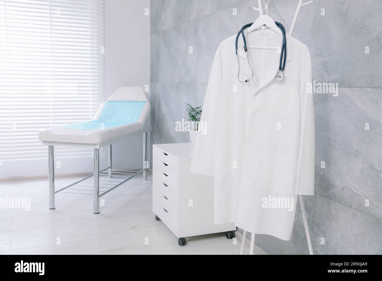 White doctor's gown and stethoscope on rack in clinic Stock Photo - Alamy