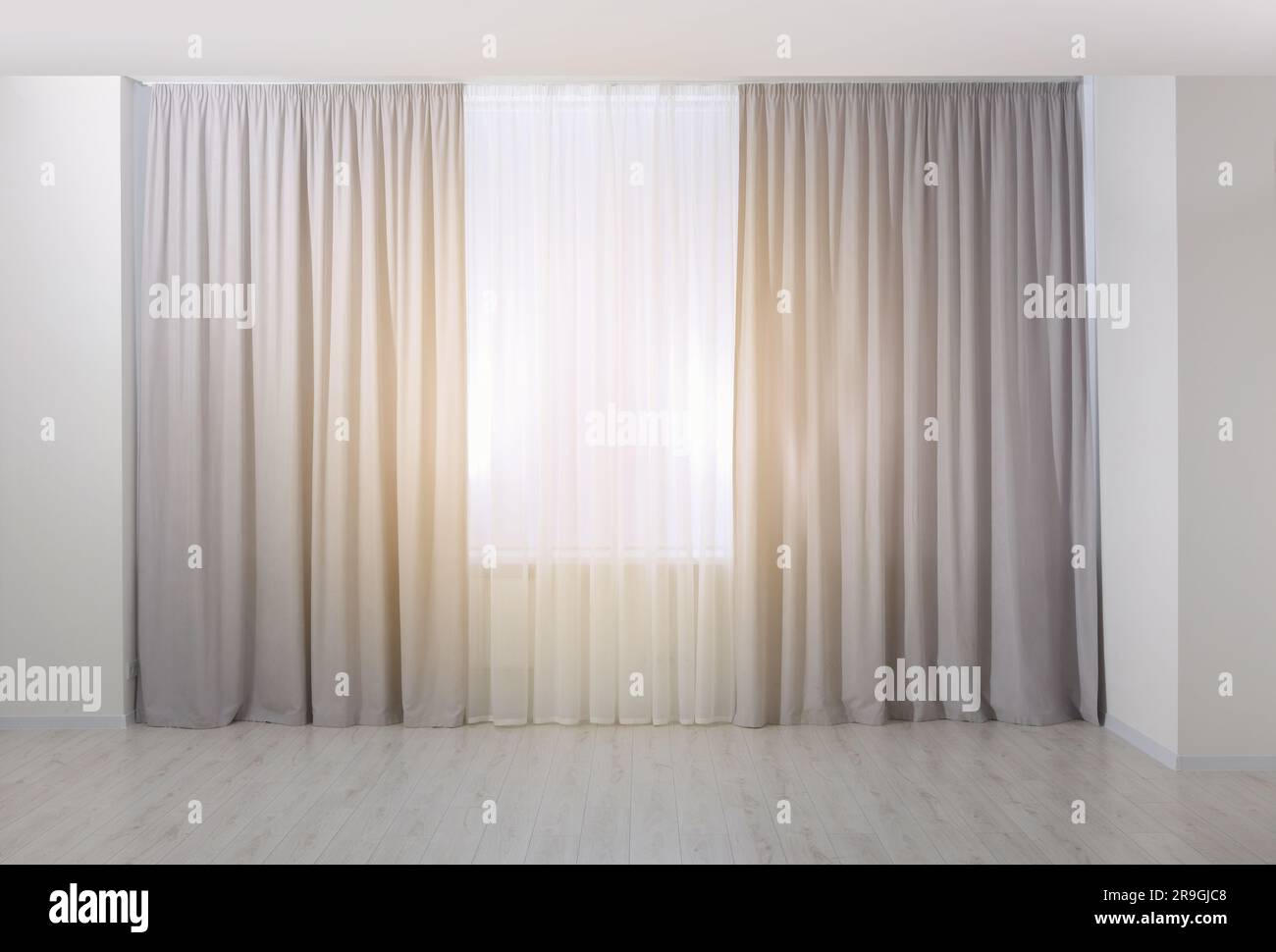 Light grey window curtains and white tulle indoors Stock Photo - Alamy