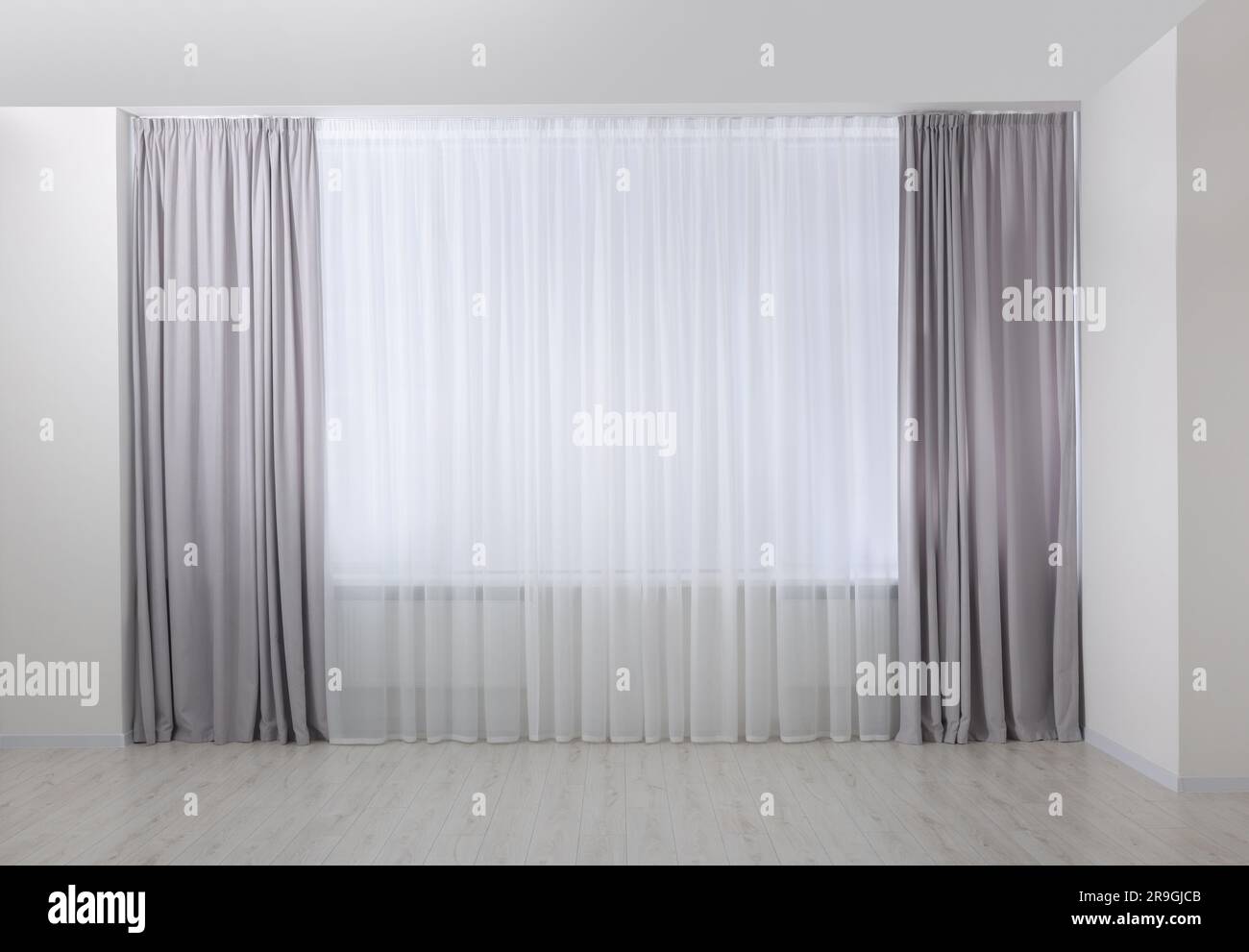 Light grey window curtains and white tulle indoors Stock Photo - Alamy