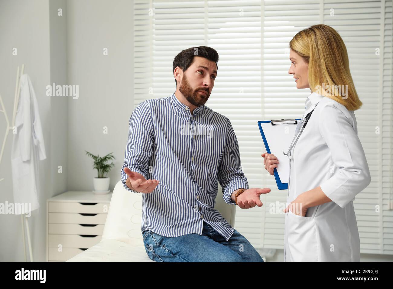 Patient having appointment with doctor in clinic Stock Photo - Alamy