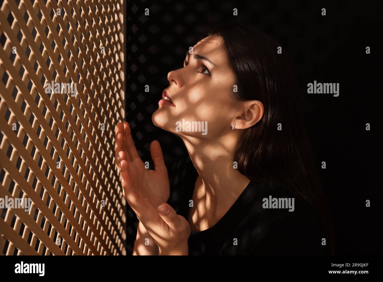 Woman praying to God during confession in booth Stock Photo - Alamy