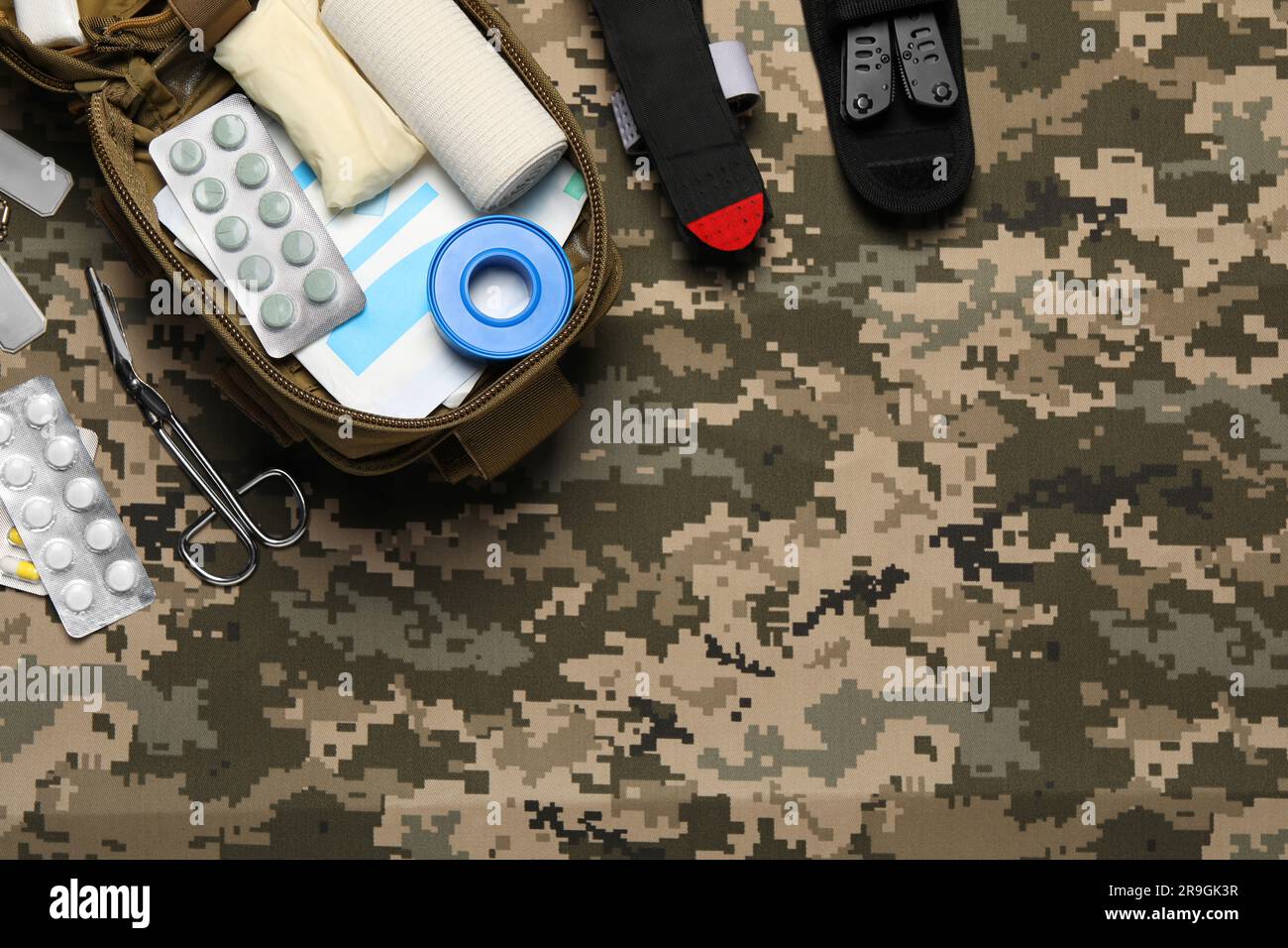 Flat lay composition with military first aid kit on camouflage fabric ...
