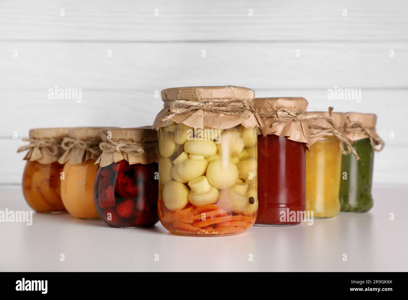 Many jars with different preserved products on light grey table Stock ...