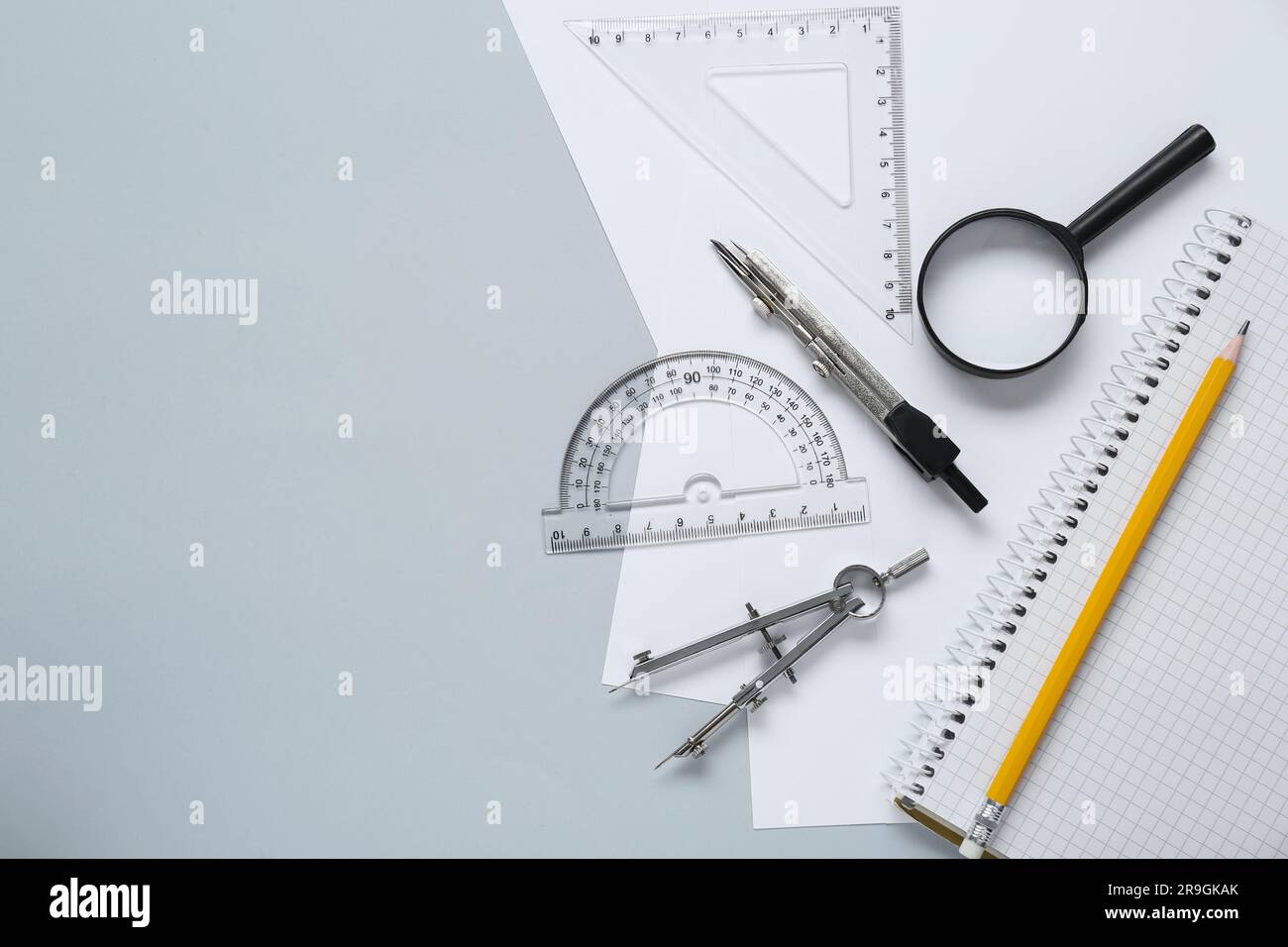 Different rulers and compasses on light grey background, flat lay ...