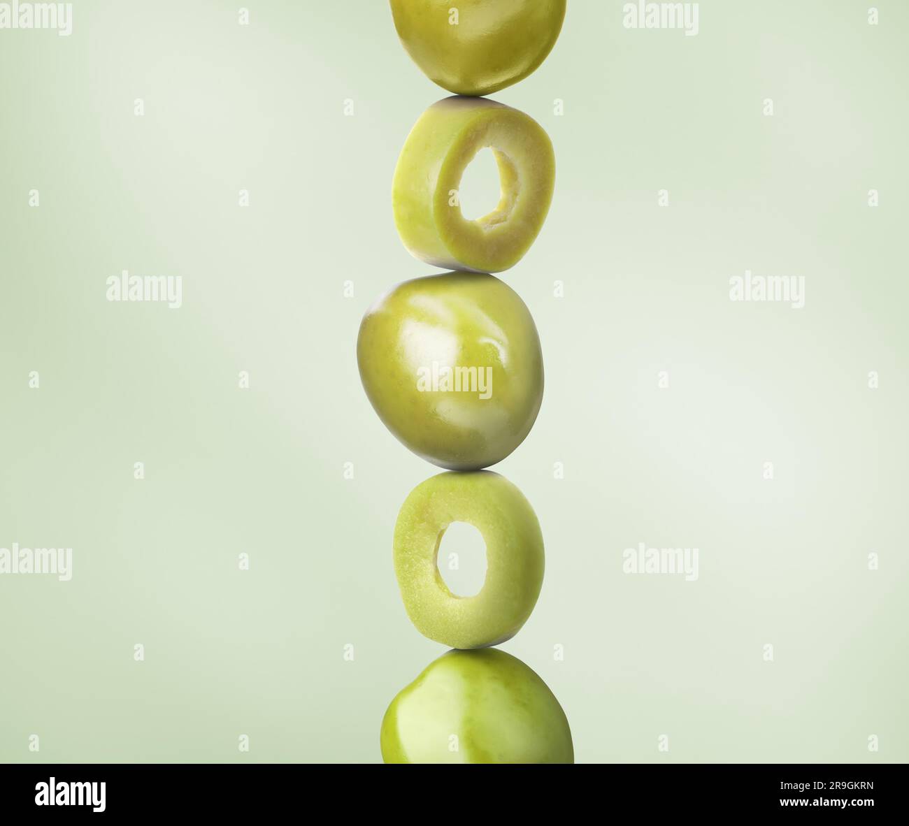 Cut and whole olives on dusty light green background Stock Photo - Alamy