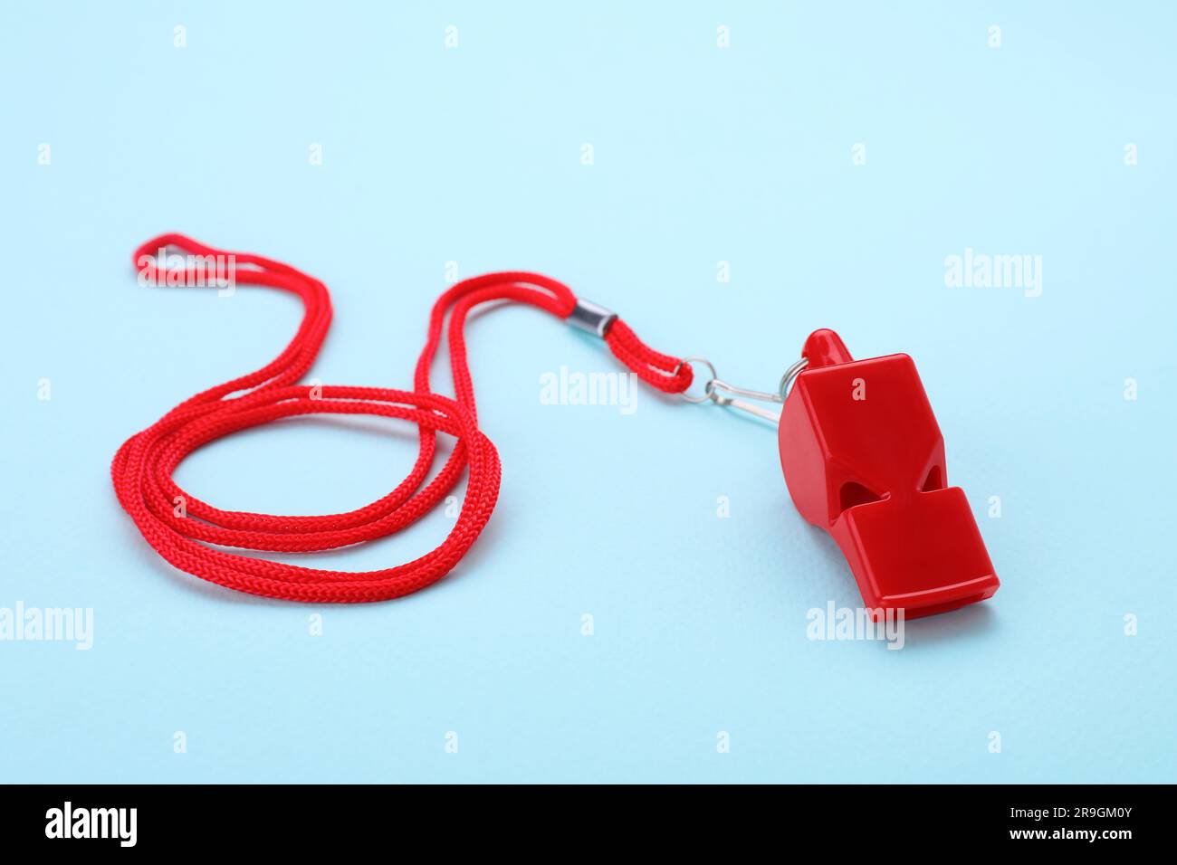 One red whistle with cord on light blue background Stock Photo - Alamy