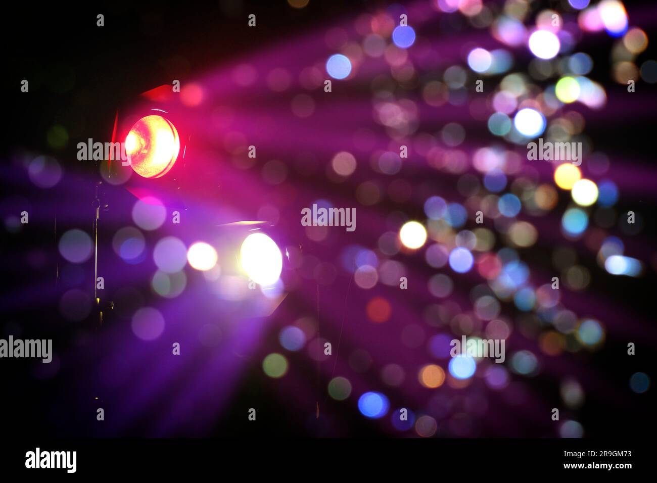Bright spotlights and beams of light in night club, bokeh effect Stock ...