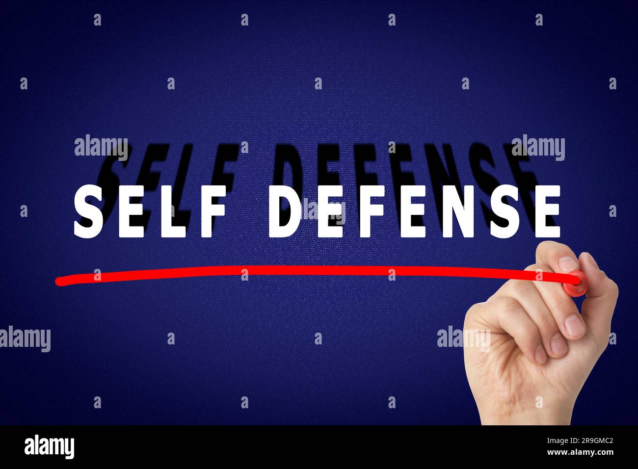 Man underlining words Self Defense with marker glass board against blue ...