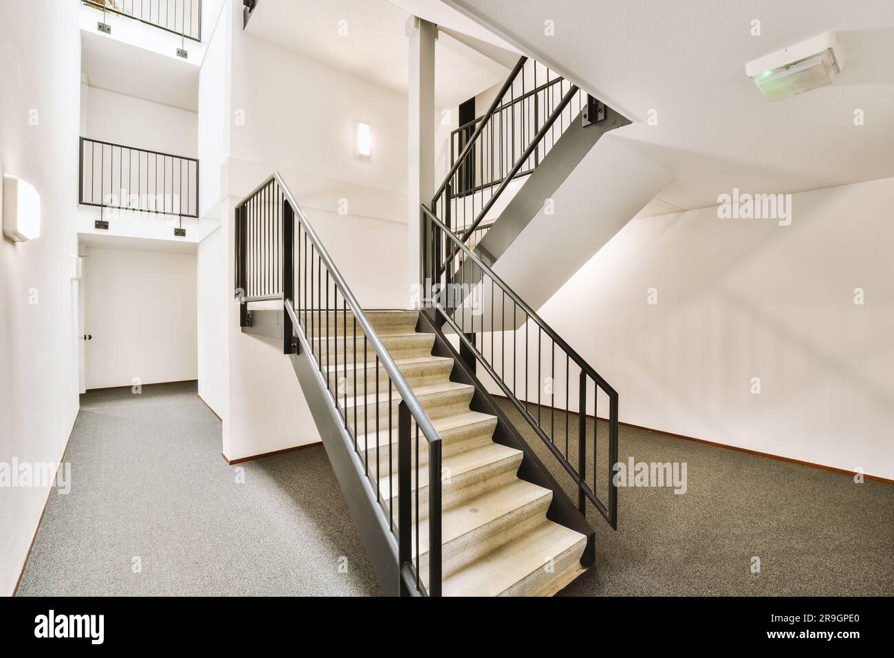 some stairs in an empty room with white walls and black railings on ...