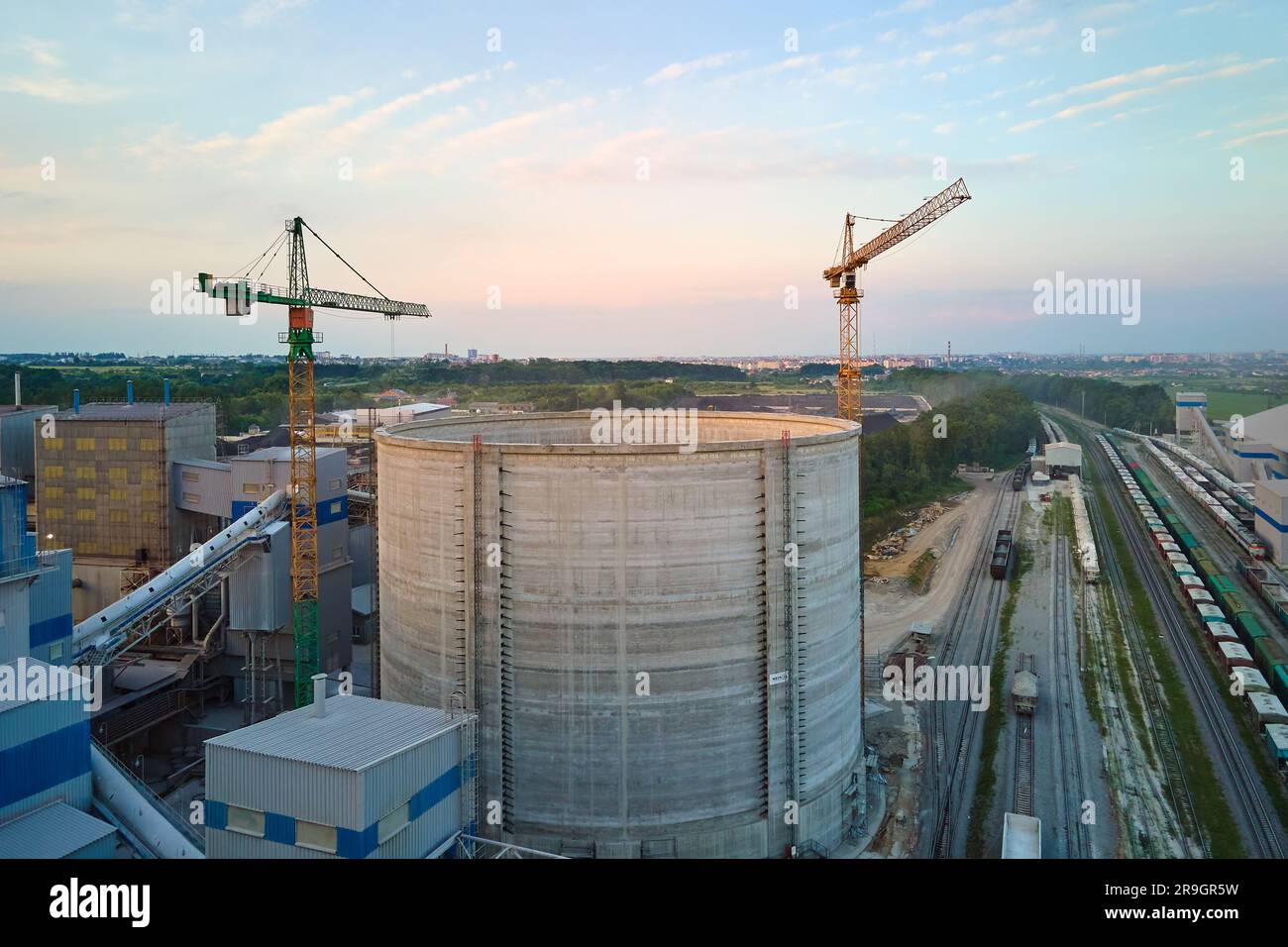 Cement plant with high factory structure and tower cranes at industrial ...