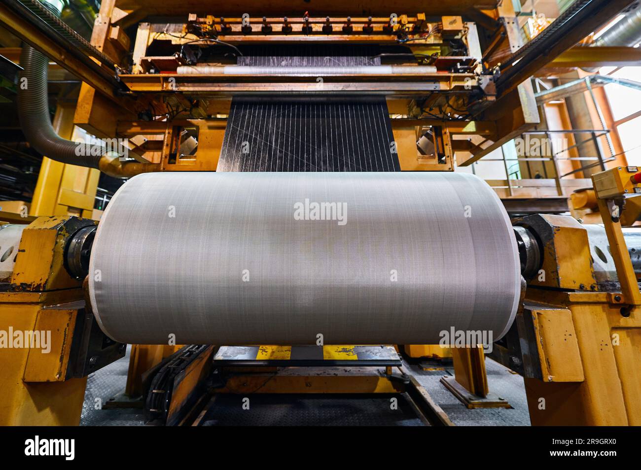 Rolling reinforced sheet on reel drum with rubber band Stock Photo - Alamy