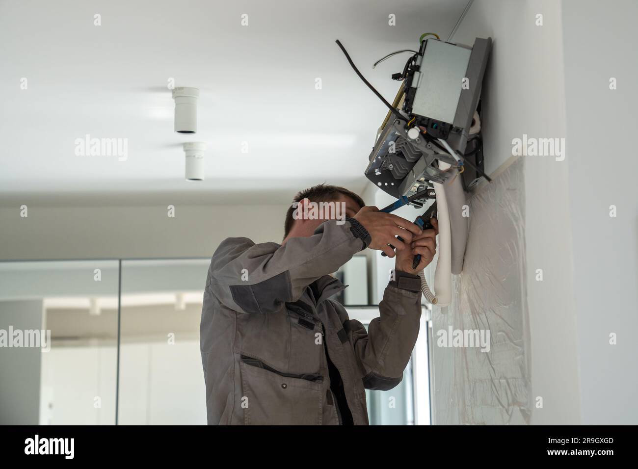 Fan cleaner and maintenance specialist installs on wall air conditioner ...