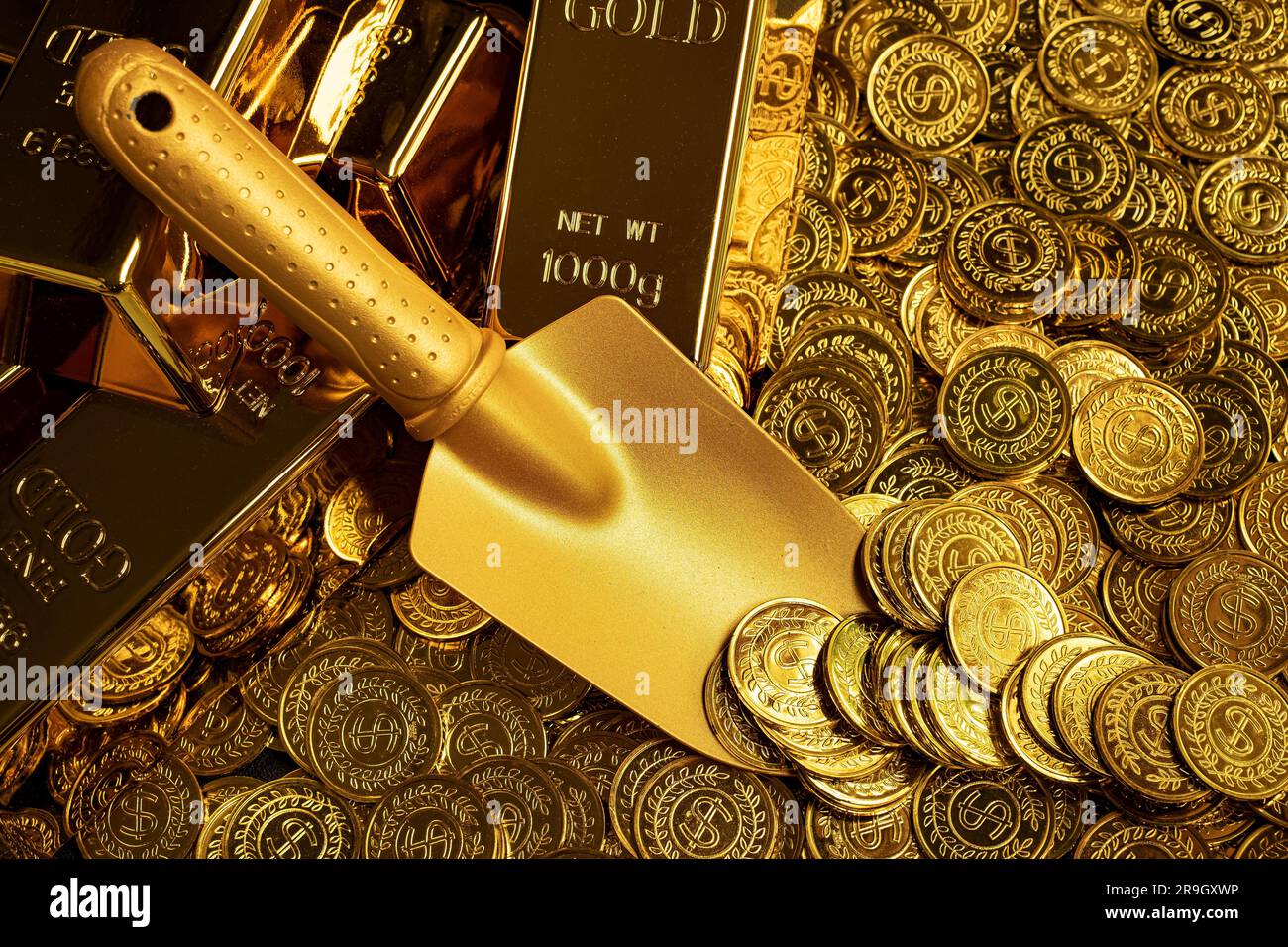 Golden shovel scooping up piles of gold coins and stacks of gold bars ...