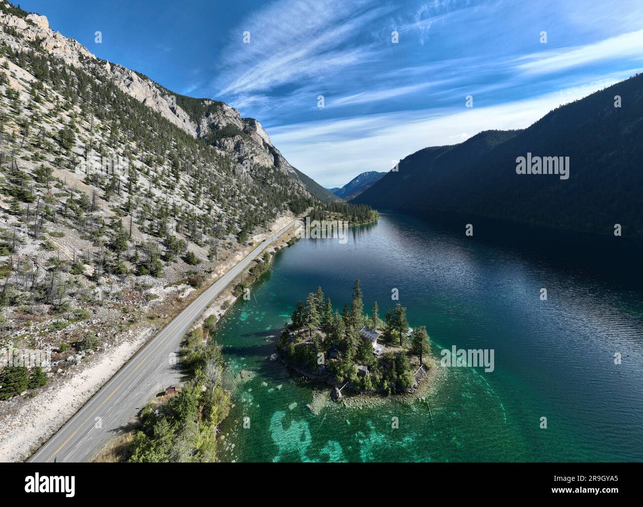 An aerial view of a road winding through a mountain range next to a ...
