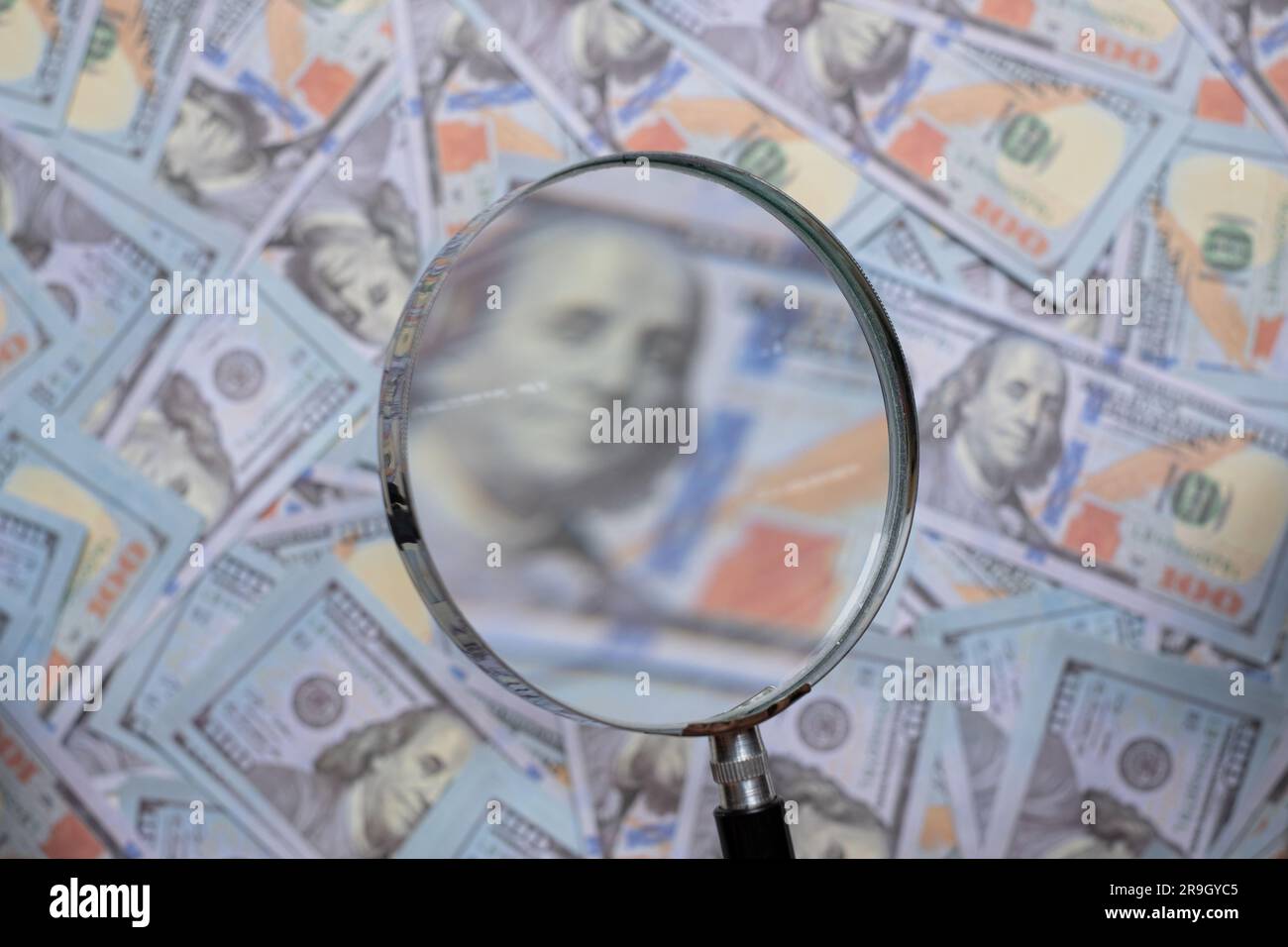 Blurred image of us dollar bill through magnifying lens checking ...