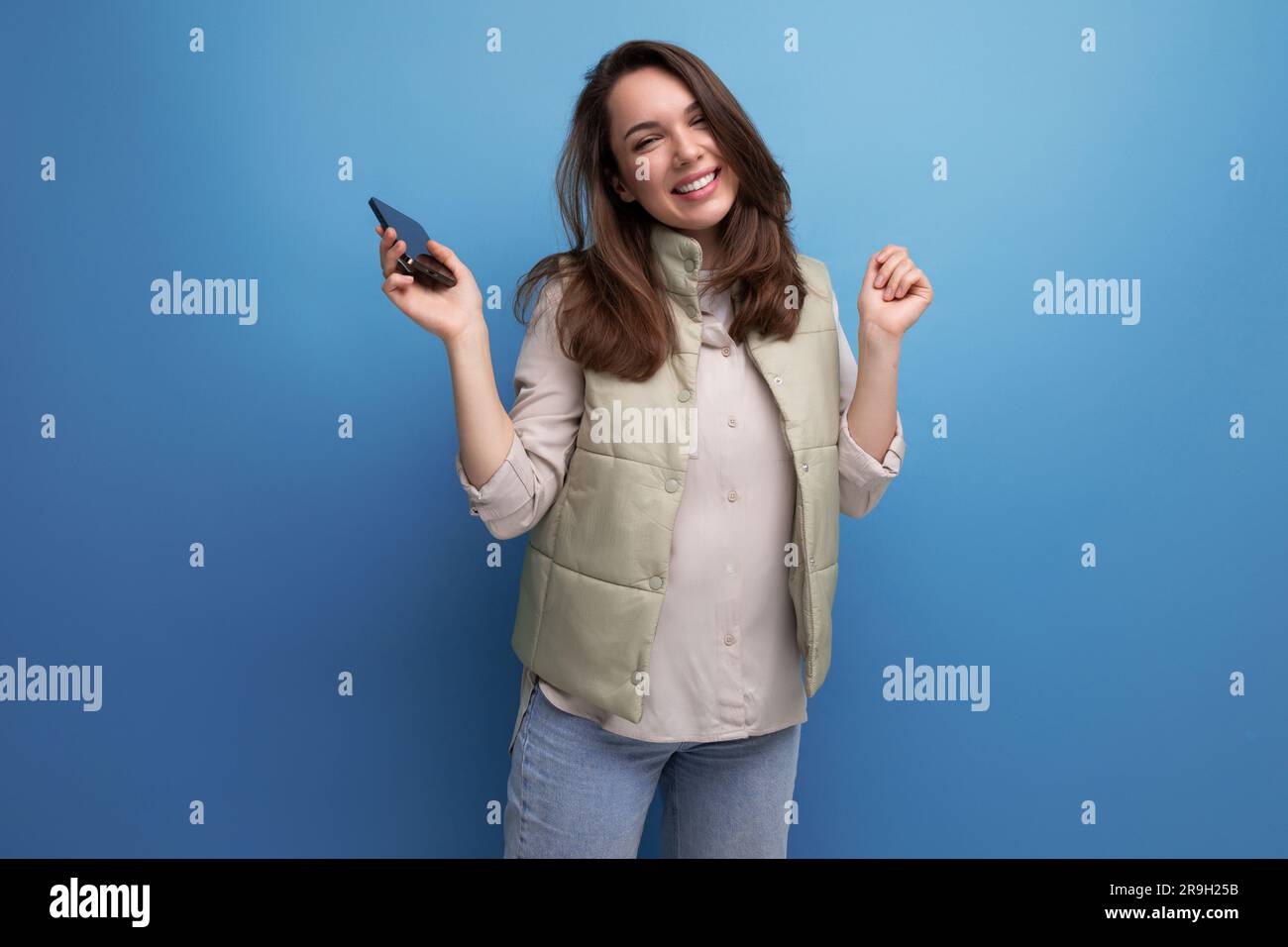 positive young brunette woman in casual clothes dancing holding a ...