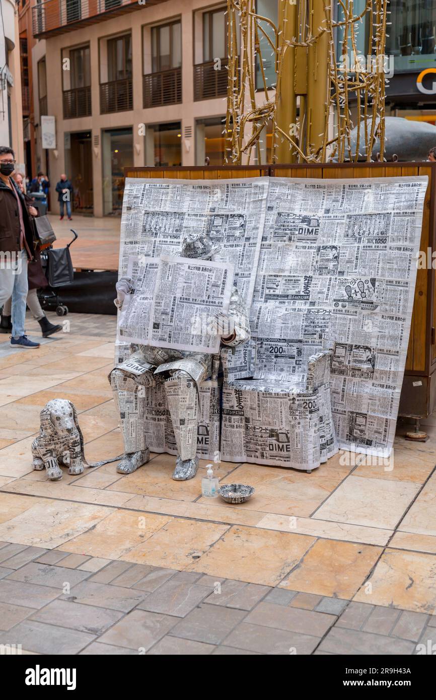 Malaga, Spain - FEB 27, 2022: Street artist performing mime reading a ...