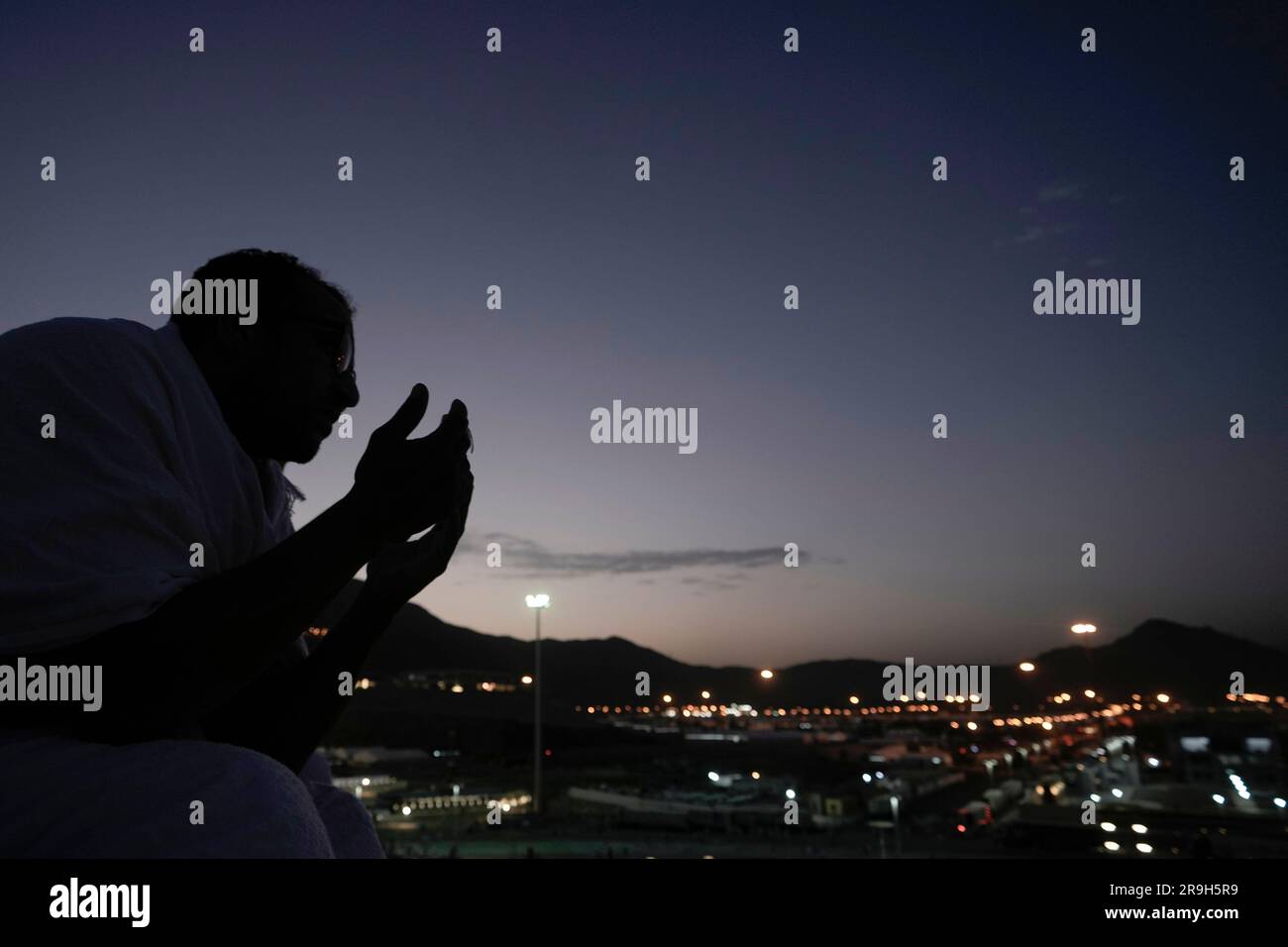 A Muslim pilgrim prays on the rocky hill known as the Mountain of Mercy ...