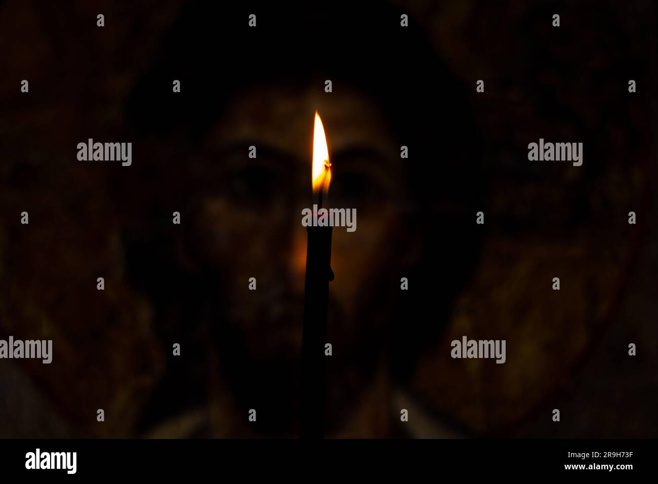 burning candle illuminates the icon of Jesus Christ Stock Photo - Alamy