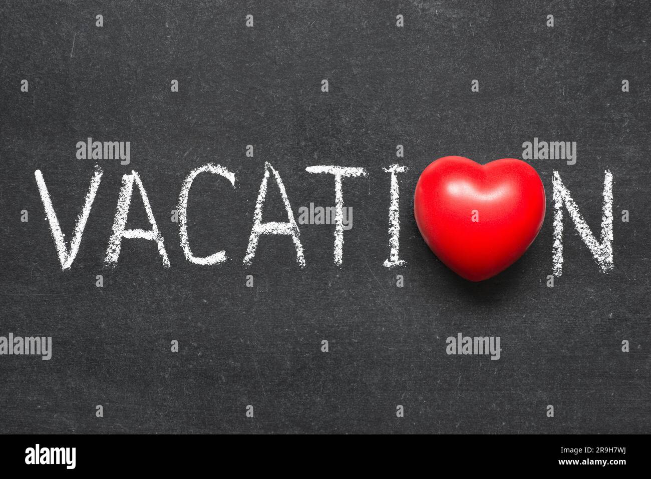 vacation word handwritten on chalkboard with heart symbol instead of O ...