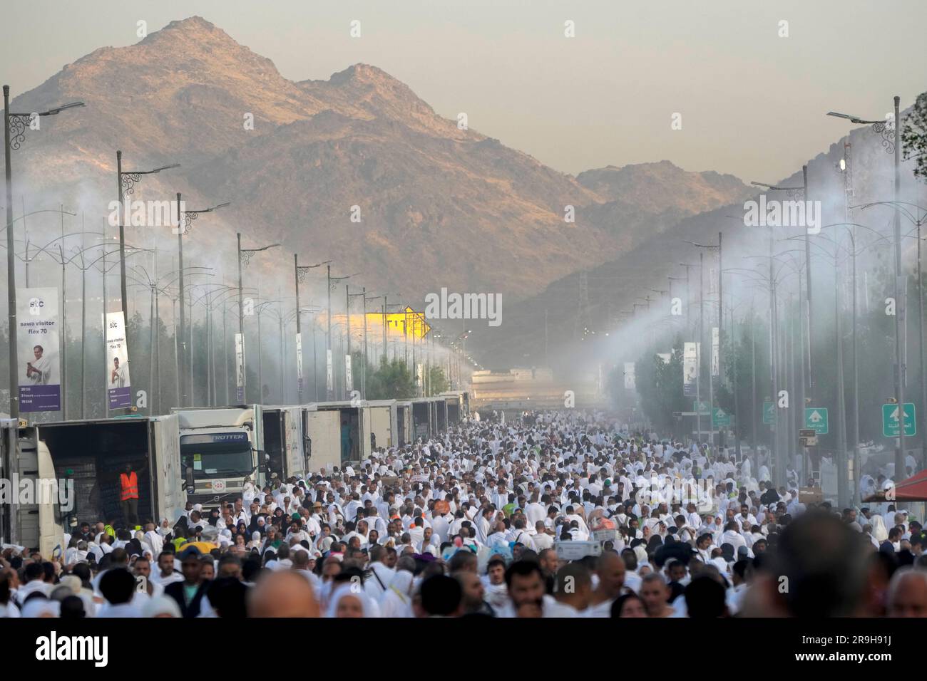 Water mist is sprayed on Muslim pilgrims as they walk towards the rocky ...