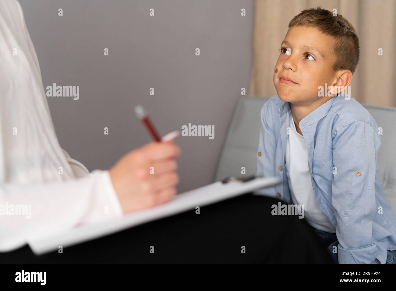 Professional child psychologist working with little boy in bright ...