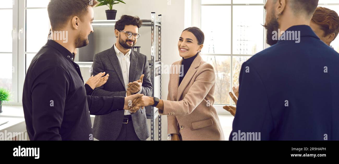 Happy young woman getting recognition for her work from her colleagues ...