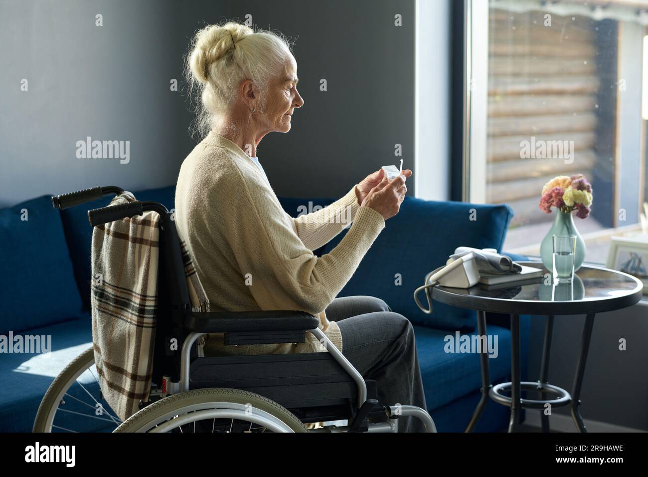 Side view of retired woman with disability going to take pill from ...