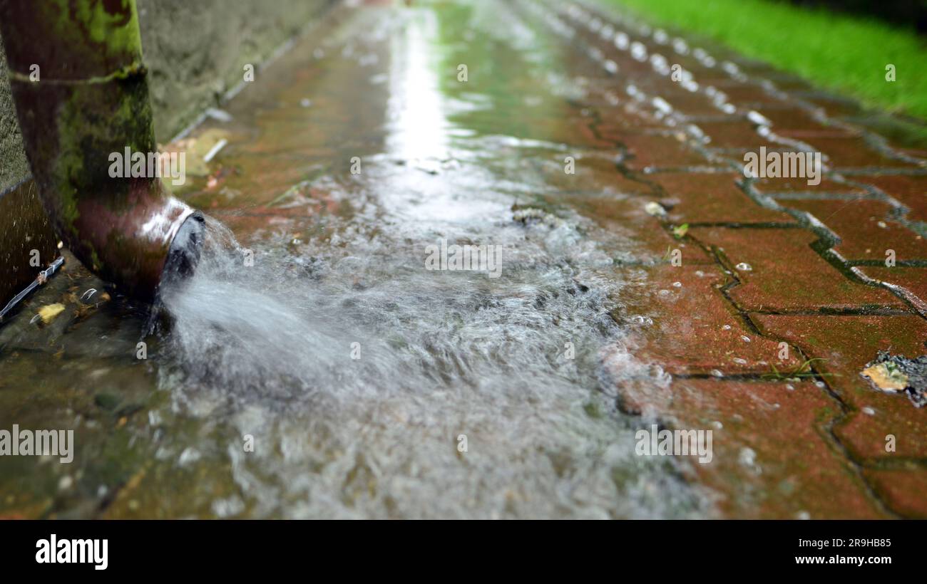 Drops of heavy rain on sidewalk surface. Rain water on the surface of ...