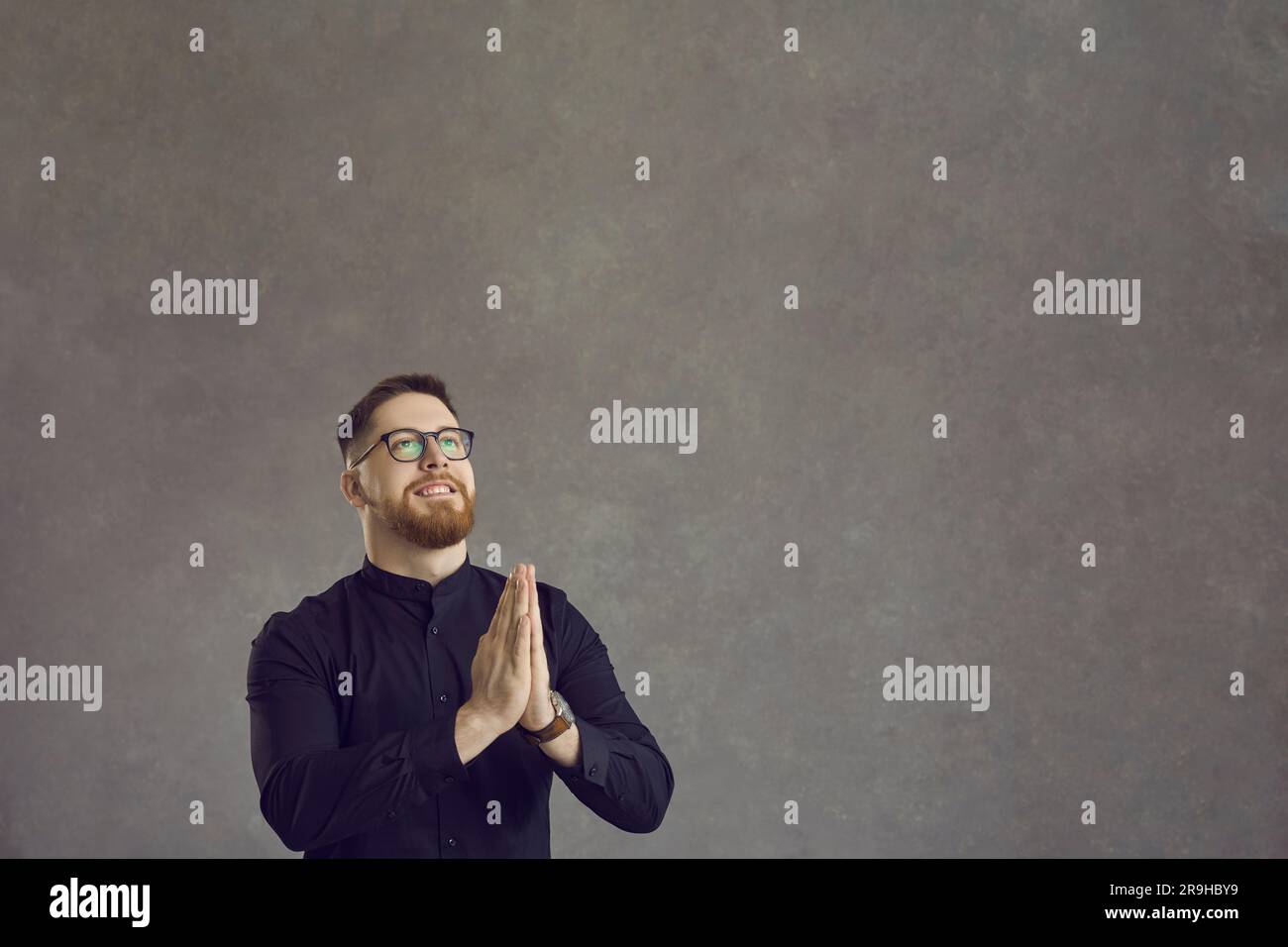 Happy man praying, making wish or asking for favor isolated on copy ...