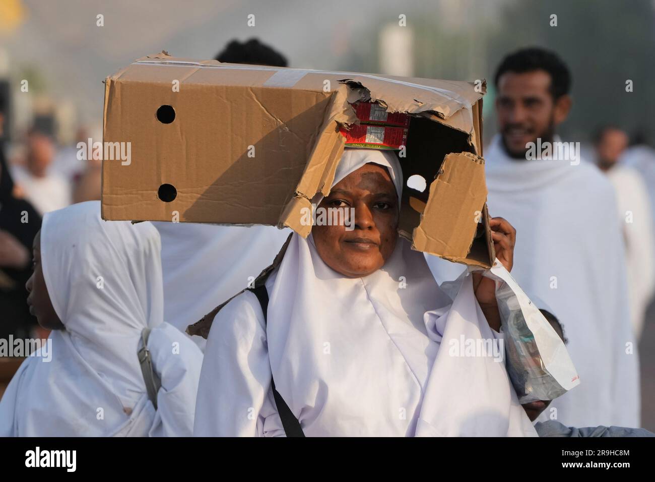 A Muslim pilgrim protects herself from the sun near the rocky hill ...