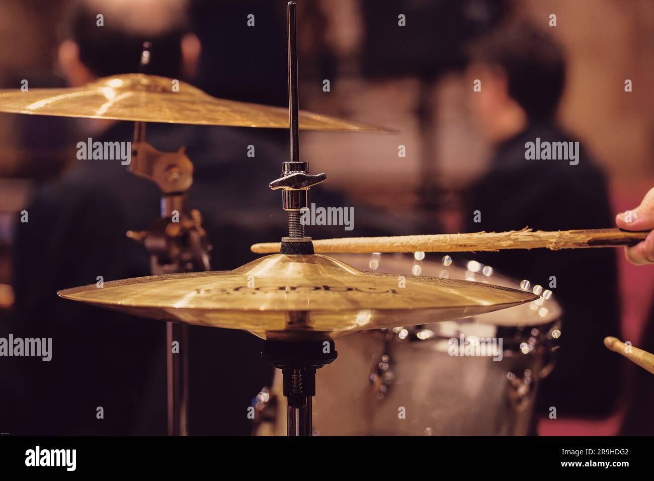 A drummer performing on a drum set, striking the drums and cymbals with ...