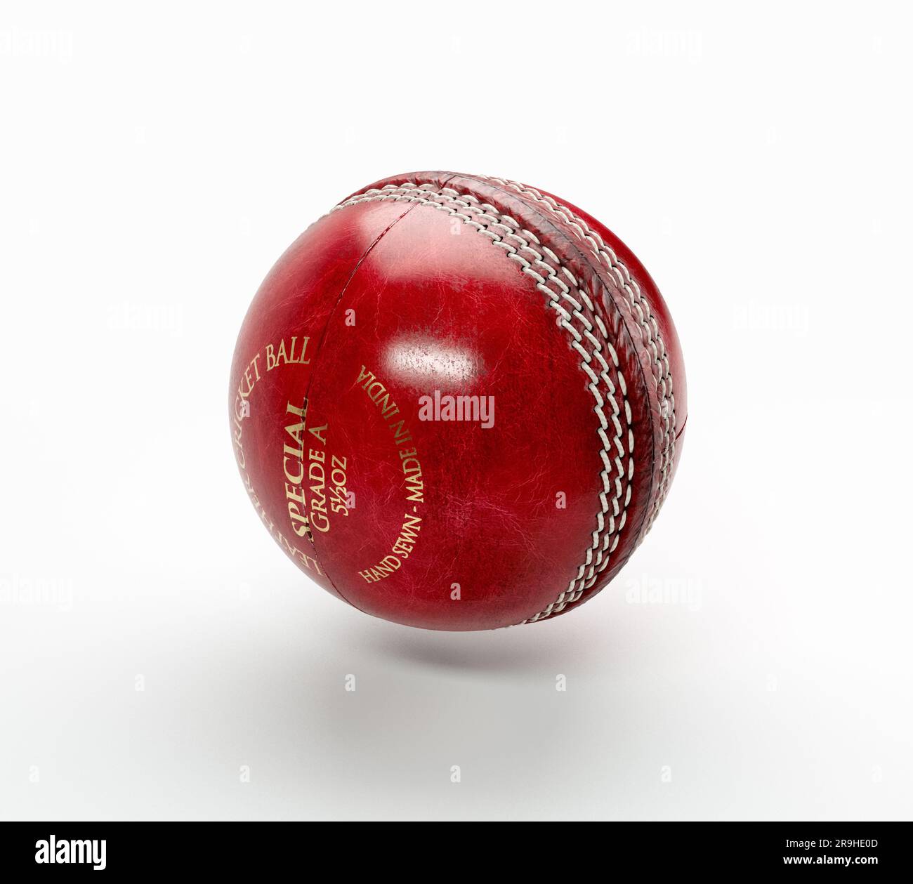 A regular red cricket ball with white stitching and generic gold ...