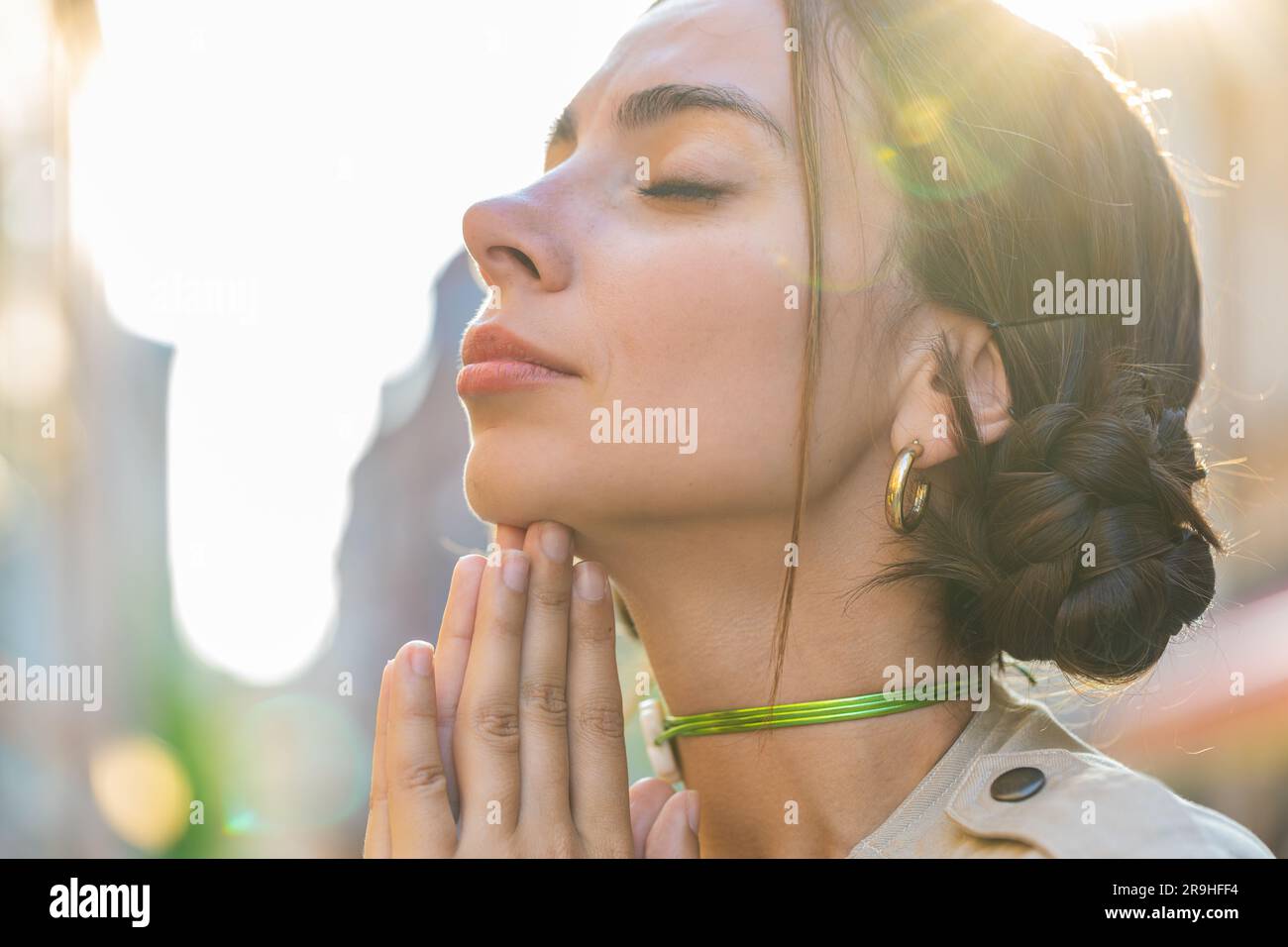 Portrait of pretty young woman praying with closed eyes to God asking ...