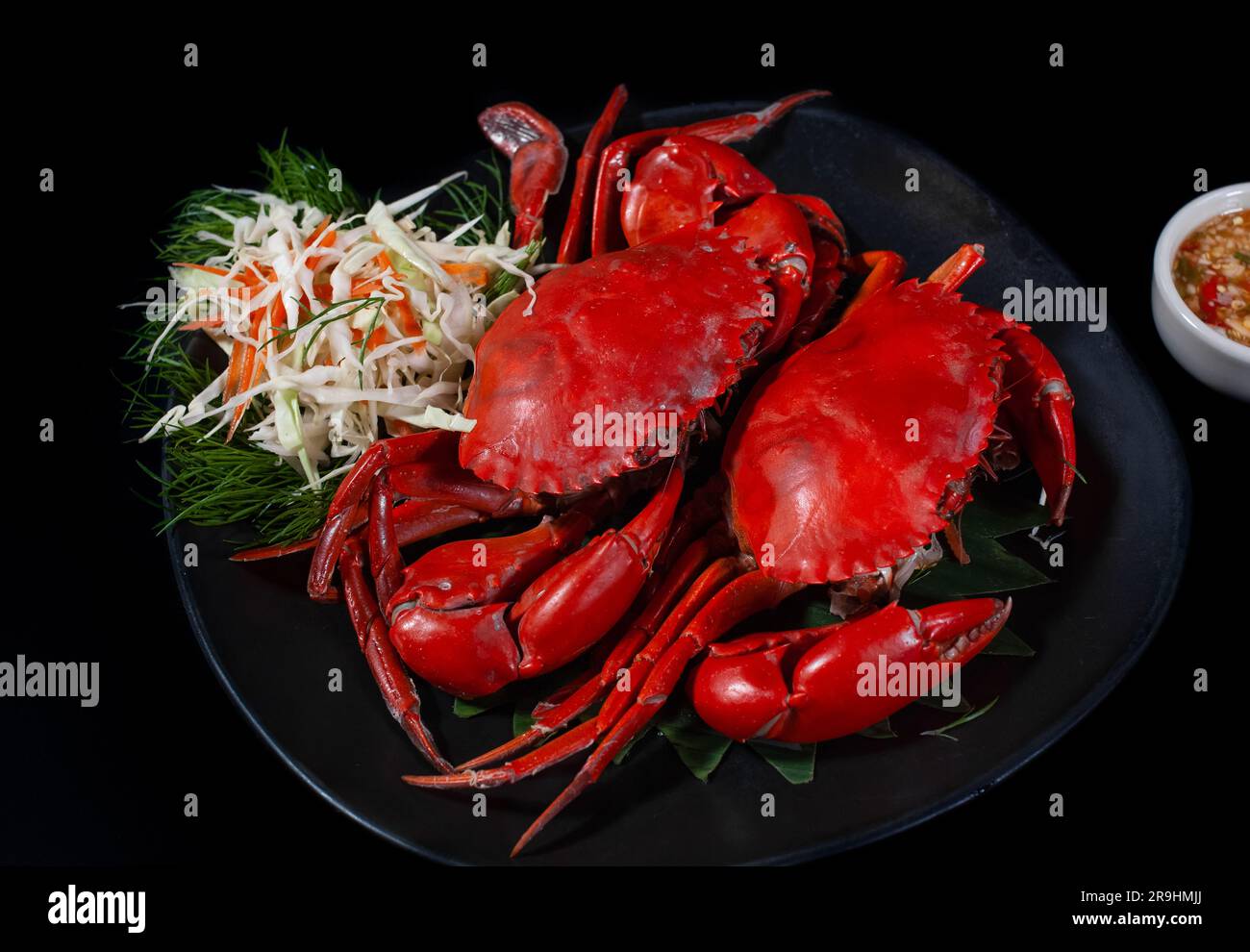 Closeup Steamed crabs on black plate served spicy sauce Thai style Stock Photo - Alamy