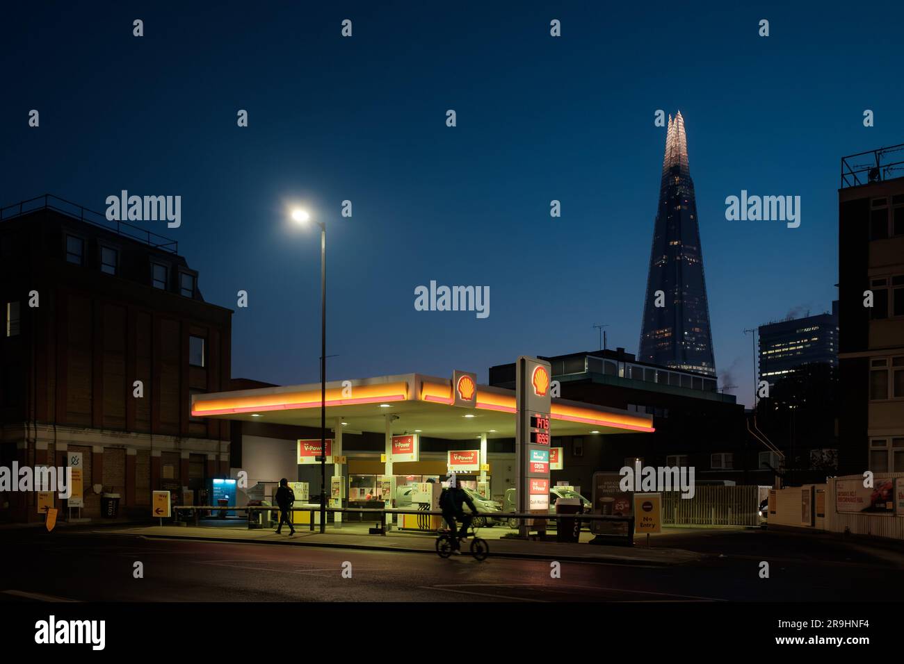 The Shard skyscraper building beyond an illuminated Shell Plc petrol ...