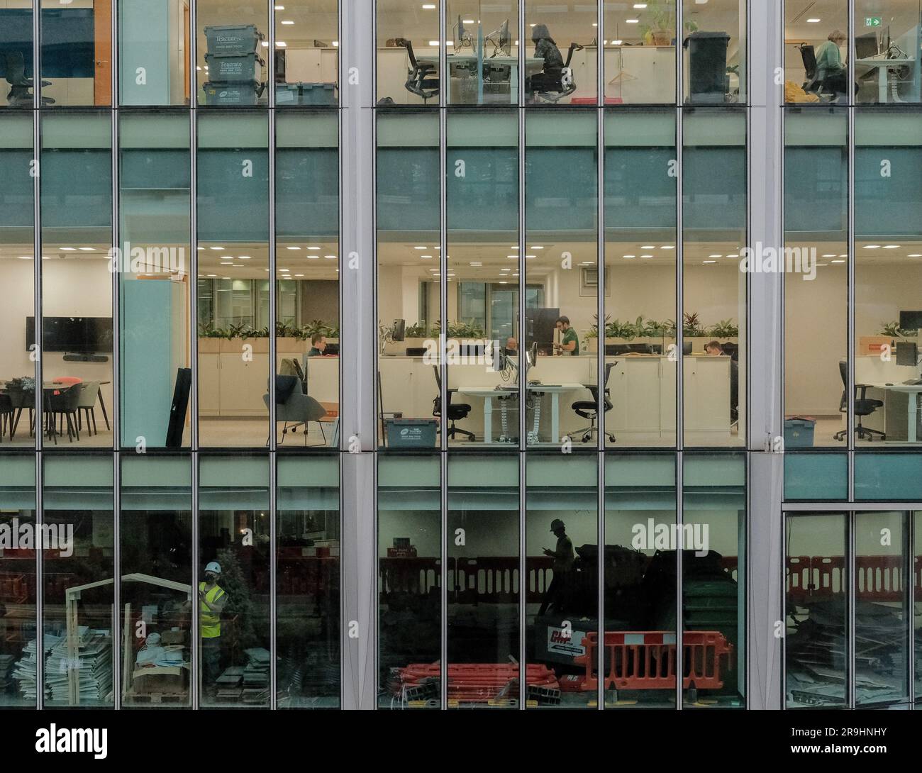 Construction workers on a building site on the level below workers in ...