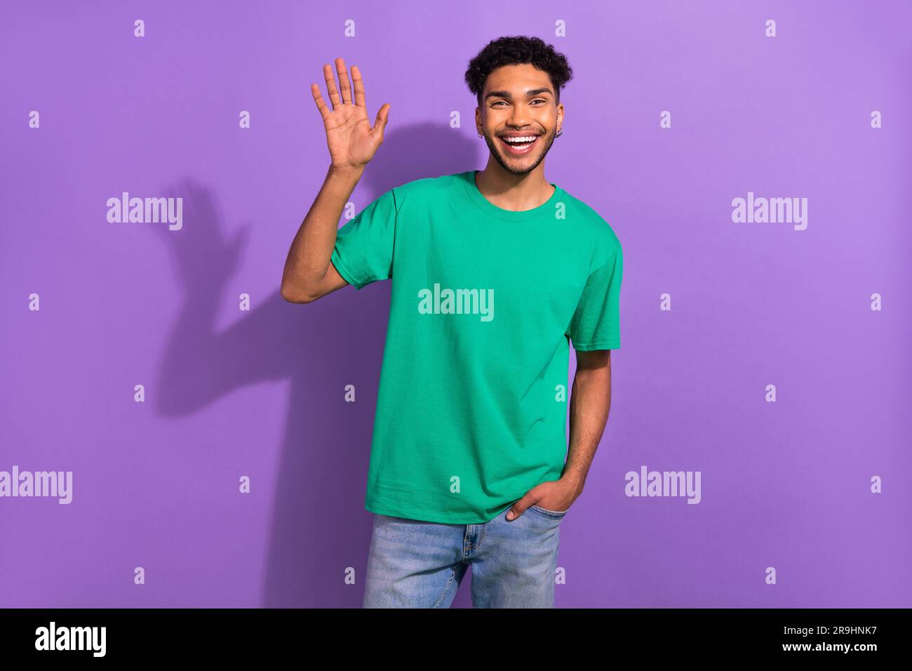 Photo of funny handsome guy model waving his arm say hello meet friends ...