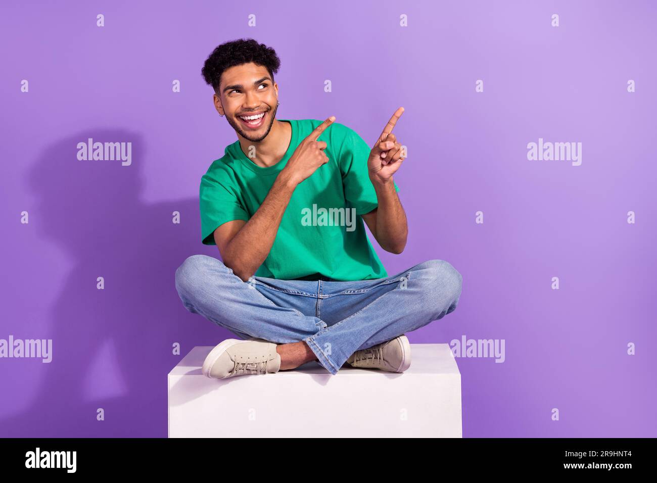 Full length cadre of young funny guy sitting box platform point fingers ...