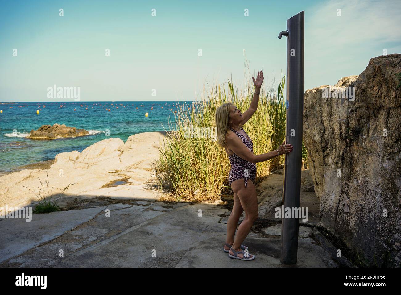 angry old woman looking at shower on the beach because there are no ...